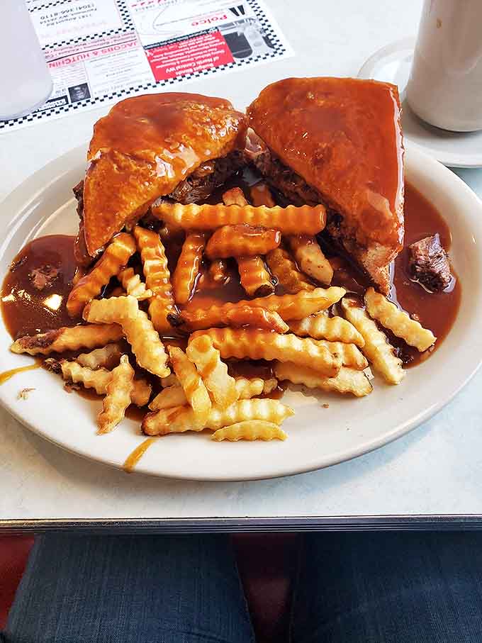 Hot roast beef sandwich swimming in gravy with a side of fries that are happily joining the pool party. Napkins required, regrets forbidden.
