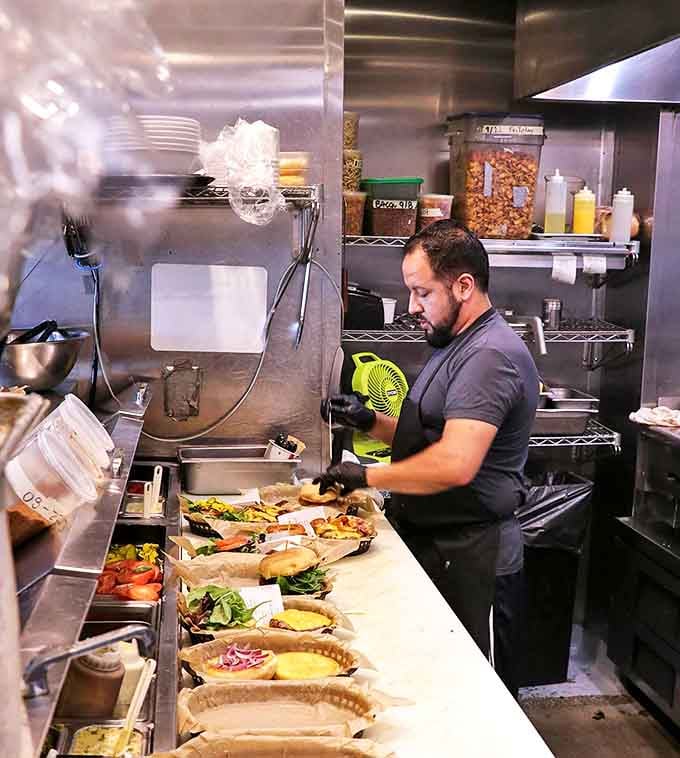 The wizard behind the curtain, crafting burger perfection. That focused expression? That's the face of someone who takes deliciousness seriously.