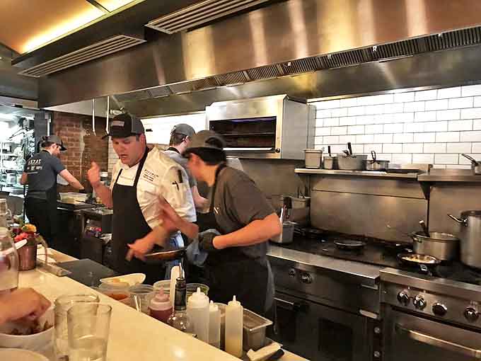 The open kitchen operates with the precision of a Swiss watch, with chefs orchestrating culinary symphonies behind gleaming stainless steel.