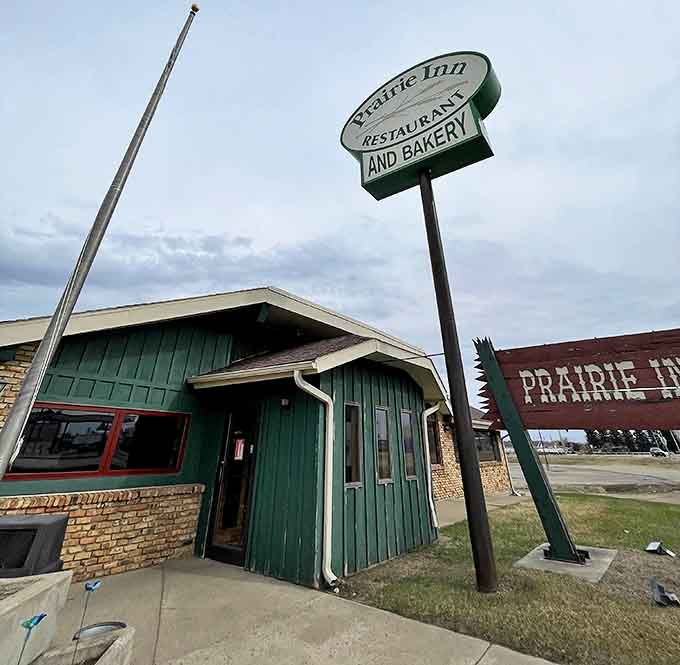 The Prairie Inn's weathered sign has guided hungry travelers for decades, promising home-cooked meals that taste like North Dakota on a plate.