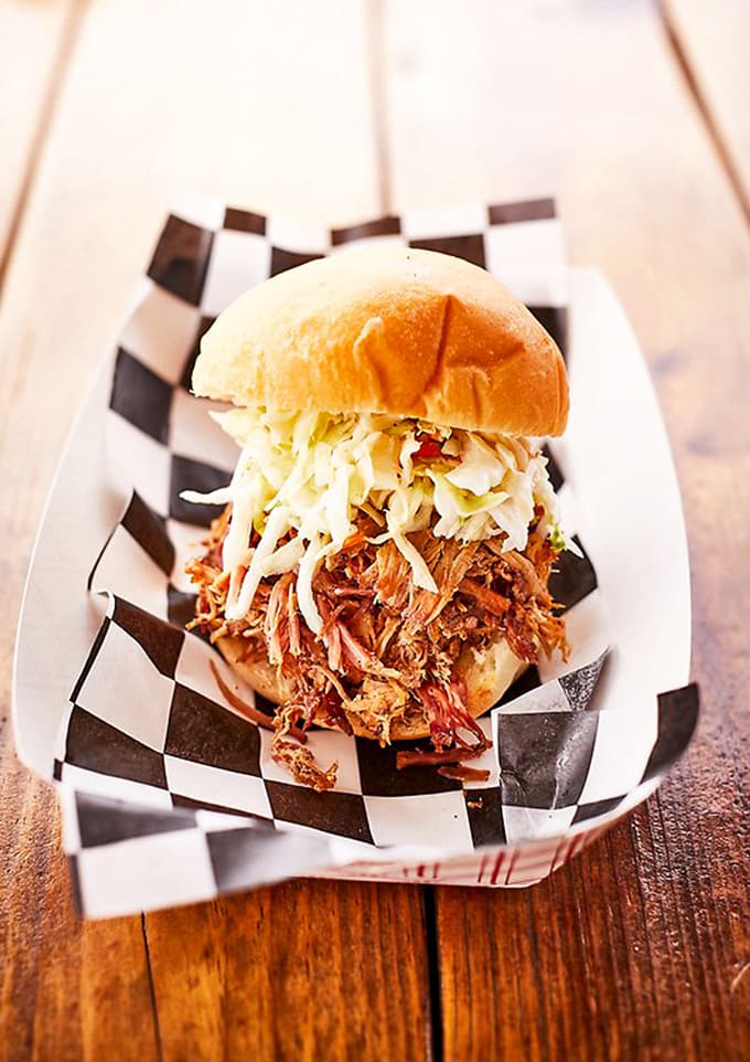 A pulled pork sandwich that requires both hands and several napkins. The slaw adds crunch and cuts through the richness perfectly.