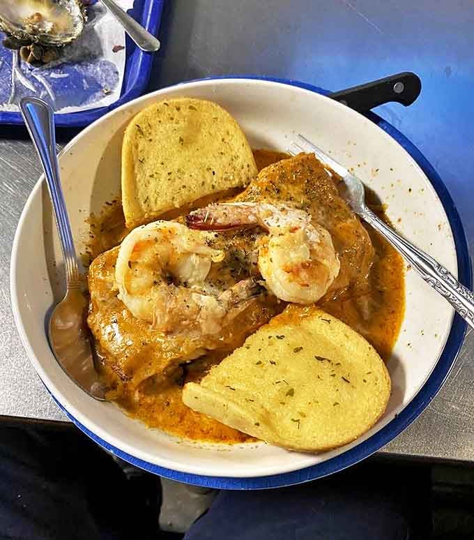Seafood swimming in sauce with garlic bread lifeguards standing by. This bowl demands to be sopped up to the last delicious drop.