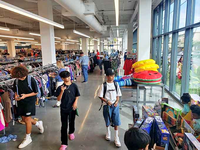 The thrill of the hunt in action. Young shoppers demonstrate that bargain-hunting skills transcend generations in this bright, airy treasure cave.