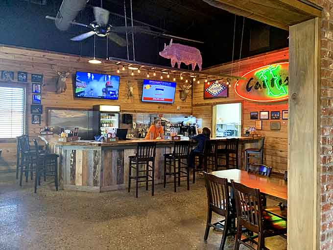 The bar where strangers become friends. Wood paneling, mounted trophies, and neon signs create the backdrop for Arkansas storytelling.