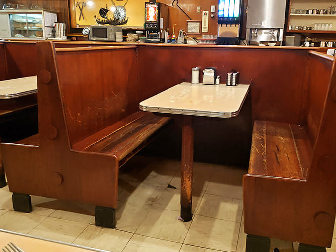 These booths have heard more town secrets and family celebrations than any therapist in Minnesota. The worn wood speaks of decades of elbows and conversations.