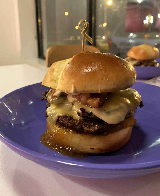 This burger, secured with a golden skewer, isn't just food&mdash;it's architecture with melted cheese as its crowning glory.
