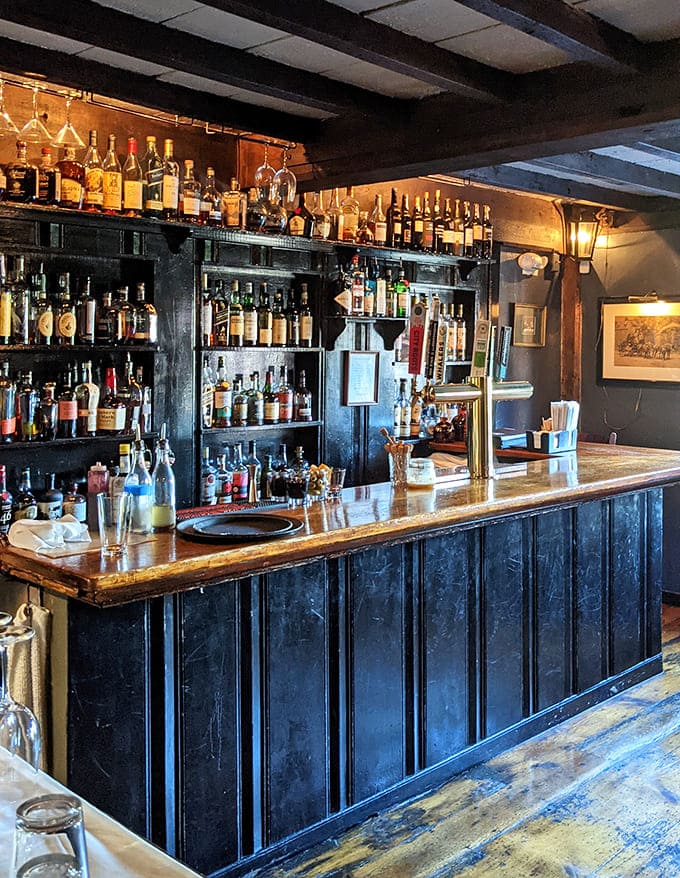 Where spirits meet spirits! The tavern's bar showcases an impressive collection that would make even Paul Revere extend his famous ride.