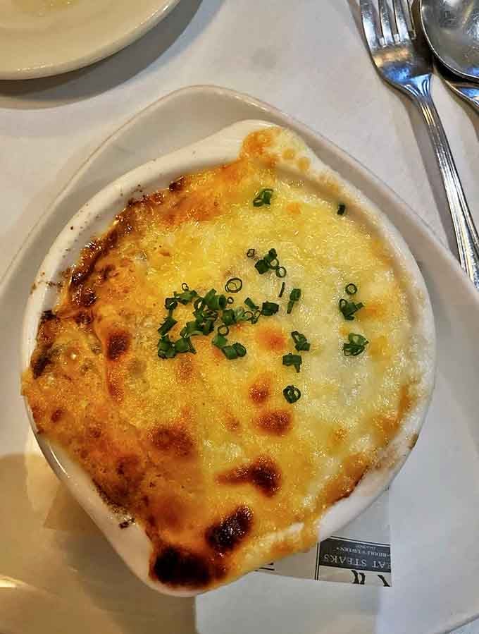 French onion soup that's wearing a golden cheese hat and isn't afraid to show it. Comfort food dressed in its Sunday best.