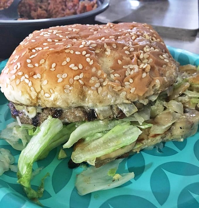 The mushroom Swiss burger showcases the beauty of simplicity &ndash; a sesame seed bun cradling a patty topped with melted cheese and fresh veggies.