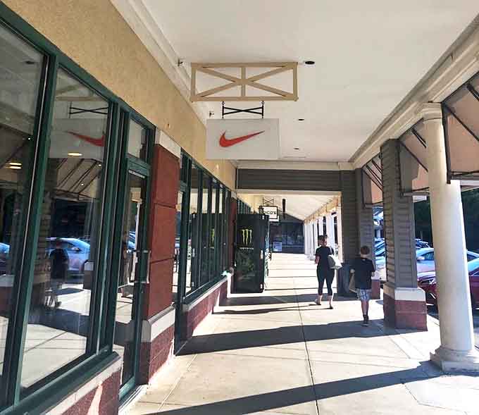 Nike's storefront promises athletic aspirations at gentler prices. The covered walkway provides shade for contemplating whether you really need another pair of running shoes (spoiler: you do).