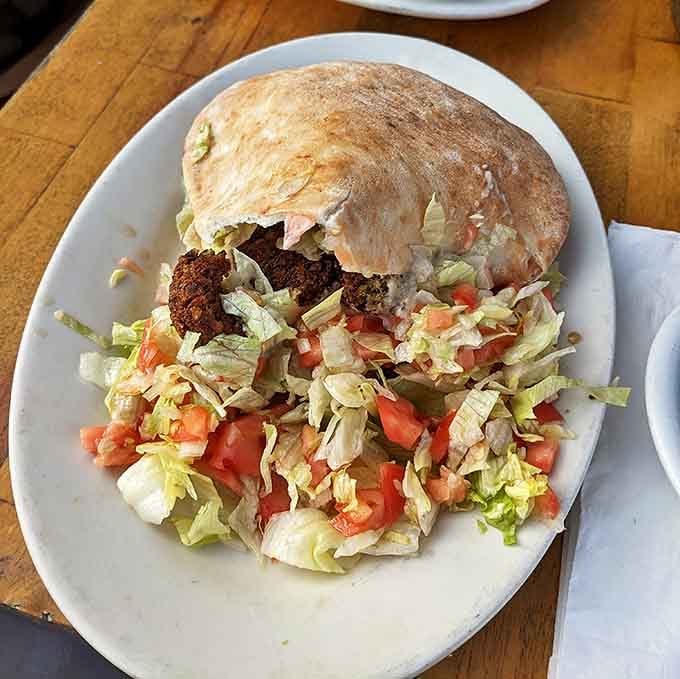 A falafel pita that doesn't just nod to vegetarians but embraces them with open arms and a shower of fresh vegetables.