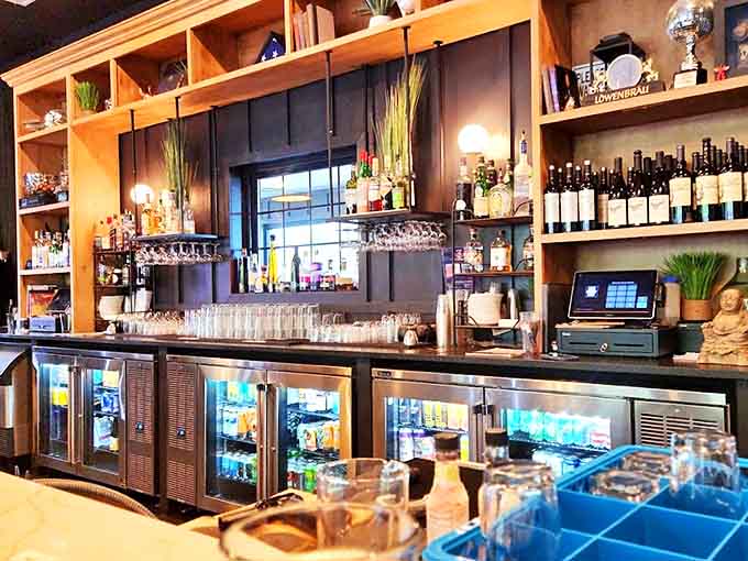 Behind this bar, bottles stand at attention like soldiers ready to serve. The warm wood shelving softens the space's modern edge.