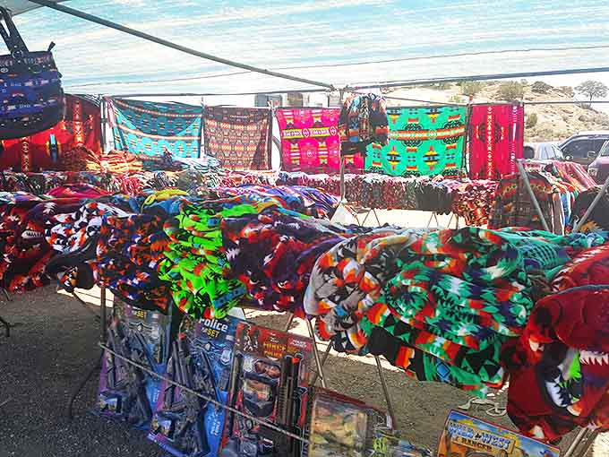 Vibrant textiles create a rainbow against the desert landscape, with traditional patterns and modern interpretations hanging side by side.