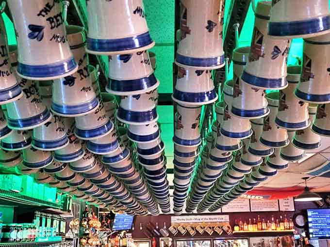 Look up and marvel at the ceiling's ceramic beer stein parade. This isn't just decoration&mdash;it's a suspended toast to centuries of brewing tradition illuminated by emerald light.