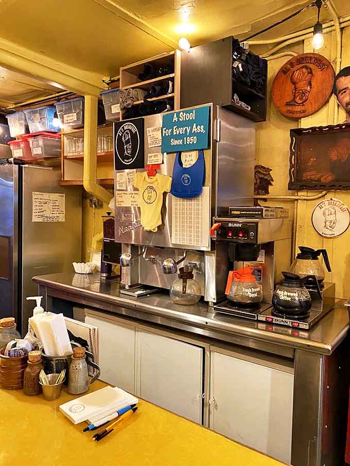 The coffee station might not look fancy, but that sign promising "A Stool For Every Ass Since 1950" tells you everything about Al's charm.