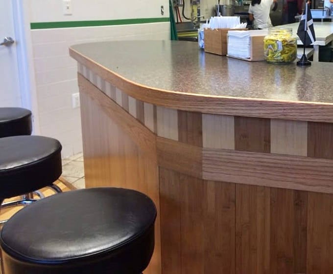 The wooden counter and stools create that perfect "neighborhood spot" vibe where regulars and first-timers feel equally welcome.