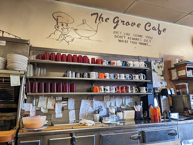 The wall of mugs tells stories of countless conversations, early mornings, and the comforting ritual of that first sip of coffee.