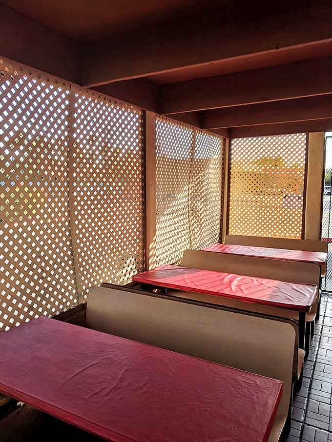 Sunlight filters through lattice dividers, creating a dappled effect that makes even the simplest meal feel like a special occasion.