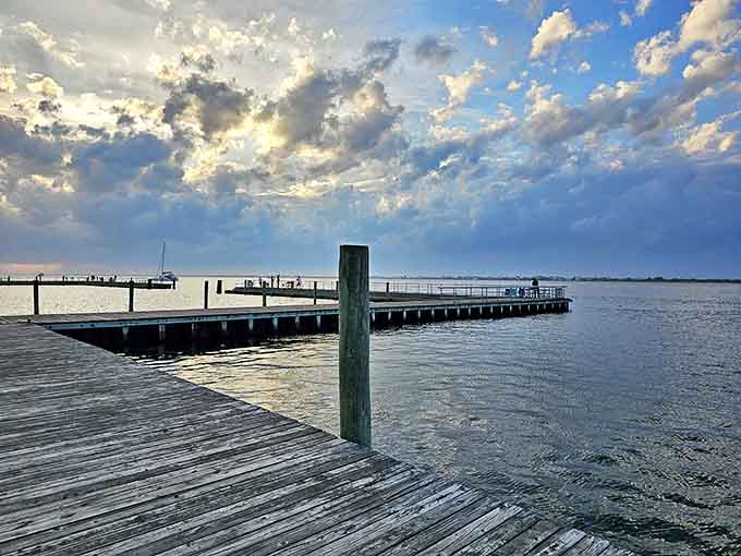 Sunset transforms this simple wooden dock into a golden pathway to tranquility, where water meets sky in a daily farewell performance.