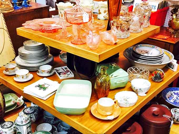 Grandma's china cabinet, reimagined! Vintage glassware and dishes arranged in a display that makes you wonder about the dinner parties they've witnessed.