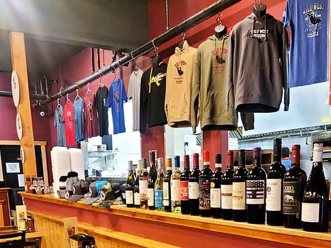 Merchandise hanging like trophies—because sometimes you need a t-shirt to prove you conquered the Wild West (of pizza, that is).