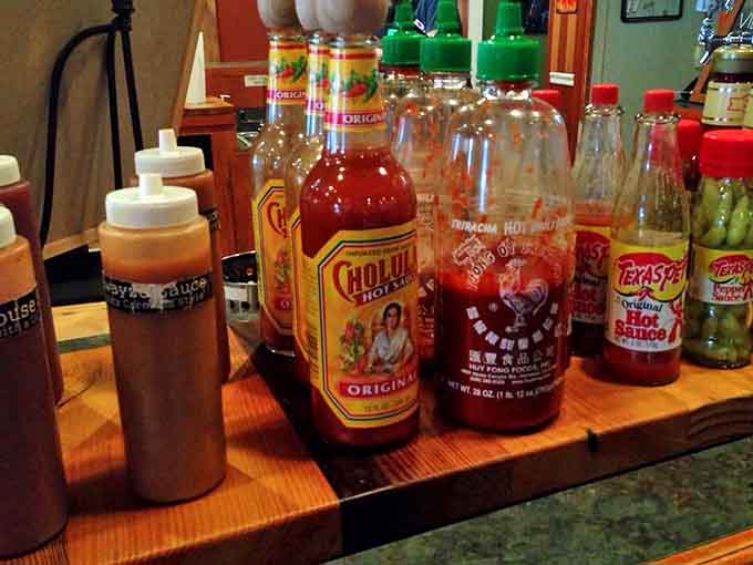 The sauce lineup—where flavor journeys begin. Each bottle a different passport to deliciousness.