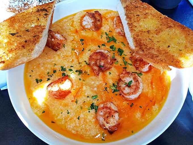 Shrimp and grits swimming in a sunset-colored sauce with Texas toast standing by, ready for the delicious mop-up operation.