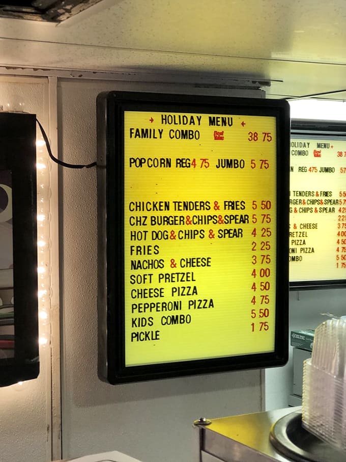 The illuminated menu board glows with temptations that haven't changed in decades&mdash;proof that some pleasures need no updating.
