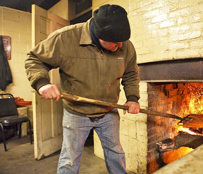 The pit master at work, tending the flames like a conductor leads an orchestra. This is where the magic happens, one careful adjustment at a time.