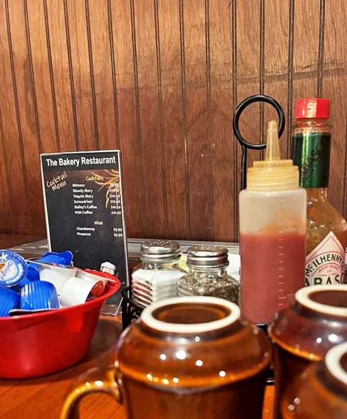 The table essentials: brown ceramic mugs, classic condiments, and that little drink menu promising liquid comfort.