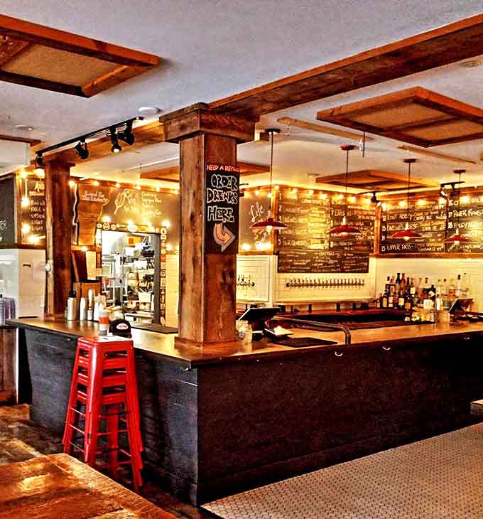 The bar area glows with warm light and possibility&mdash;a showcase of Vermont's impressive craft beverage scene waiting to be explored.