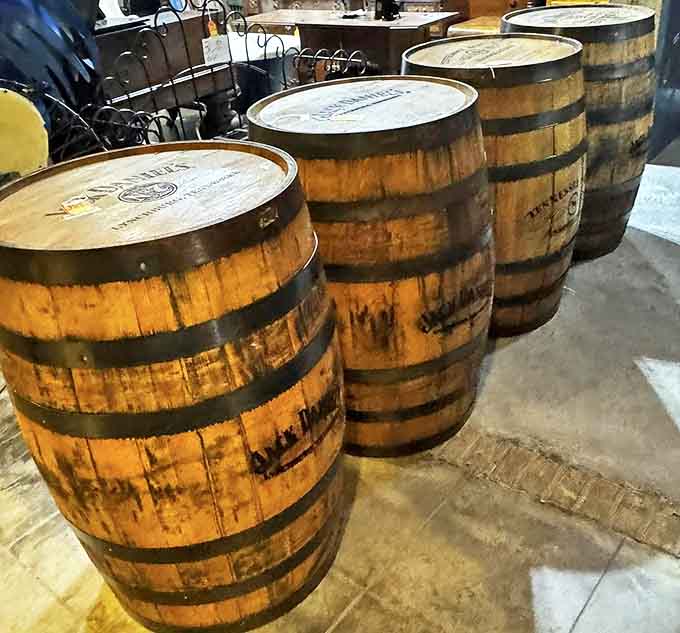 Whiskey barrels stand at attention, their staves curved from years of service, now ready for second lives as conversation-starting furniture.