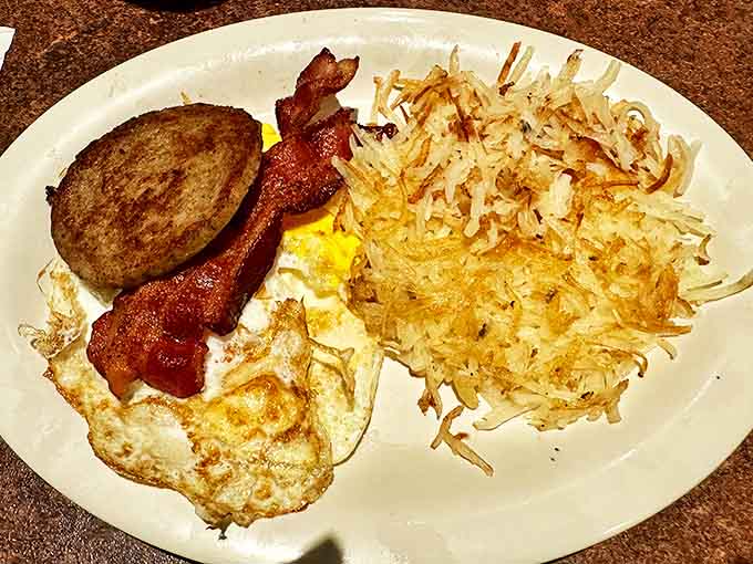 Breakfast of champions: where crispy hash browns, perfectly fried eggs, and bacon create the holy trinity of morning excellence.