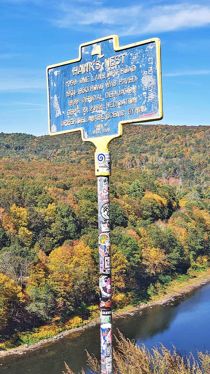 History stands tall at Hawk's Nest, where a humble sign chronicles the transformation from dirt path to bucket-list drive.