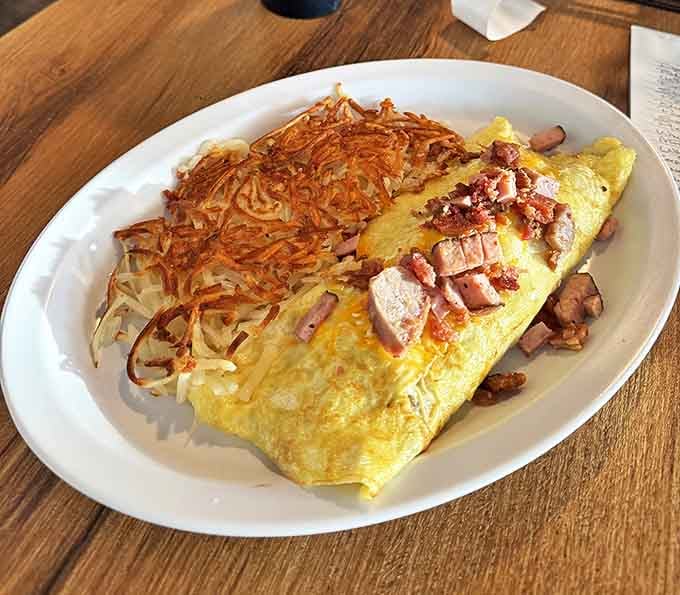 This omelet doesn't just contain ham—it celebrates it. Paired with hash browns so perfectly crispy they deserve their own fan club.