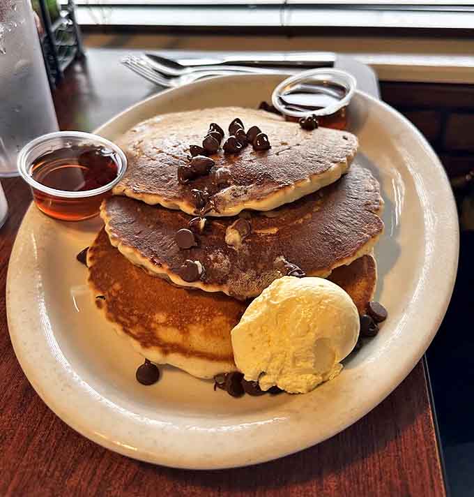 Chocolate chip pancakes stacked higher than your weekend expectations, with a scoop of ice cream that says "yes, this is allowed."