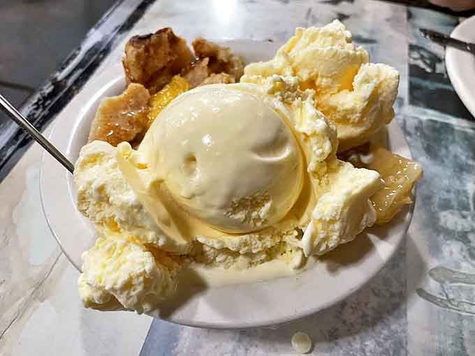 This isn't just cobbler—it's summer captured in a dessert. Vanilla ice cream melts into warm fruit like snow surrendering to spring sunshine.