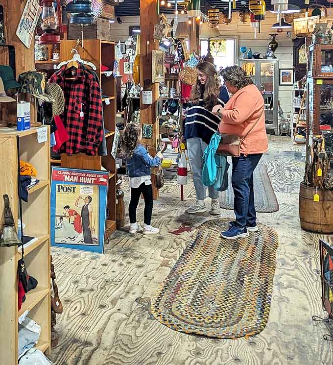 Three generations hunting treasures together, proving antiquing is a family sport. The braided rug beneath their feet has probably witnessed similar scenes for decades.