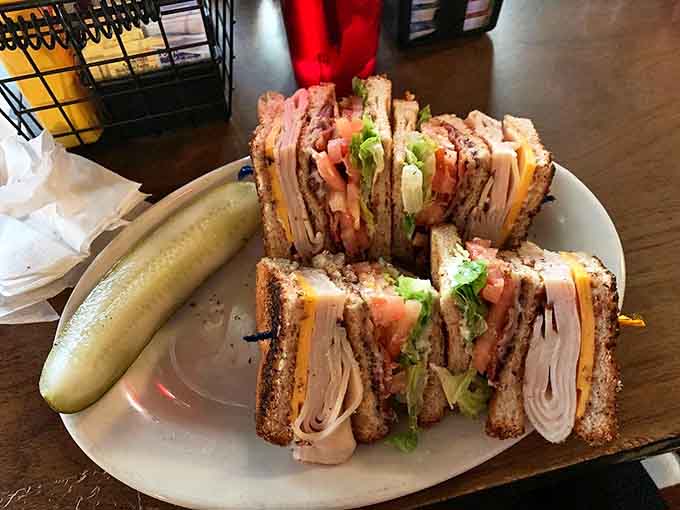 This club sandwich stands taller than some Detroit skyscrapers. Three layers of architectural sandwich brilliance with a pickle exclamation point.