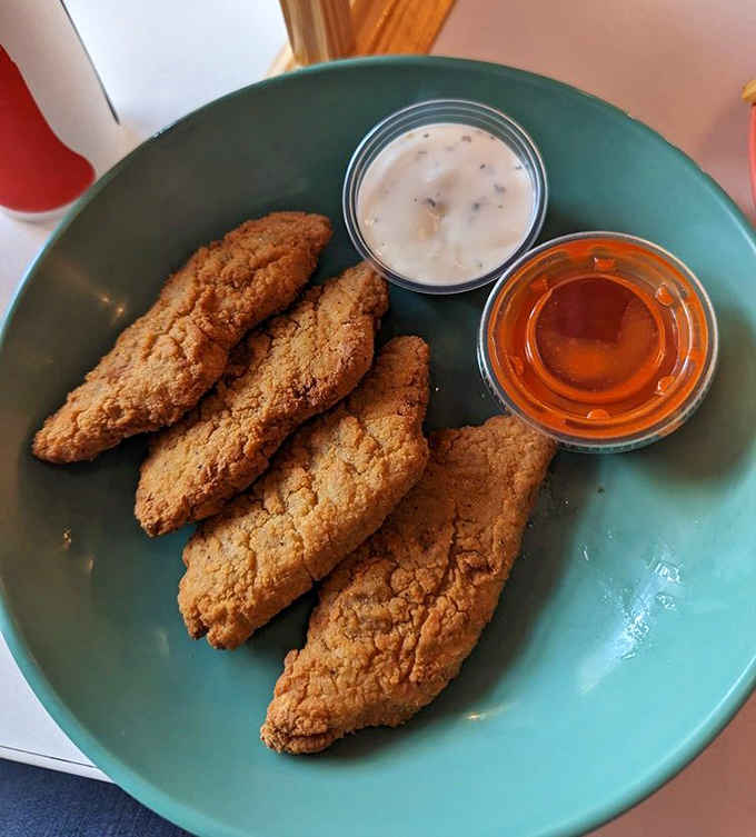 Vegan chicken tenders so convincing they've caused identity crises in actual chickens, served with dipping sauces for maximum enjoyment.