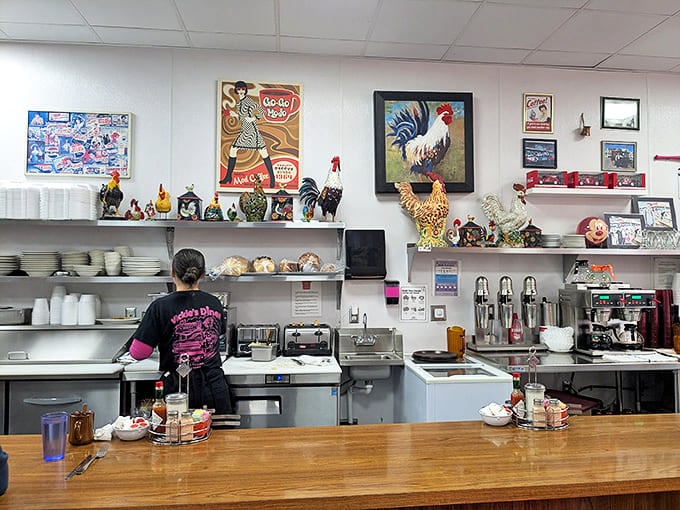 The counter view reveals the diner's secret weapon &ndash; a collection of rooster figurines standing guard over the coffee station like feathered sentinels.