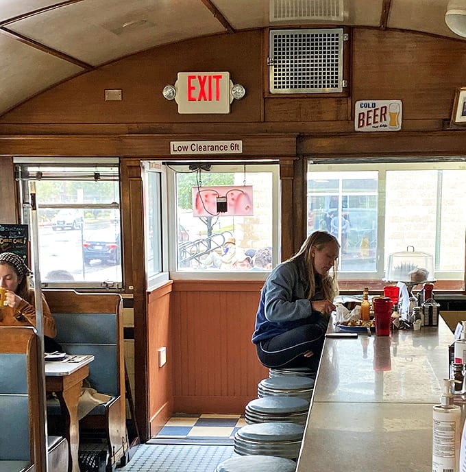 Inside the railcar section, where the low ceiling and warm wood create an intimacy that chain restaurants spend millions trying to fake.