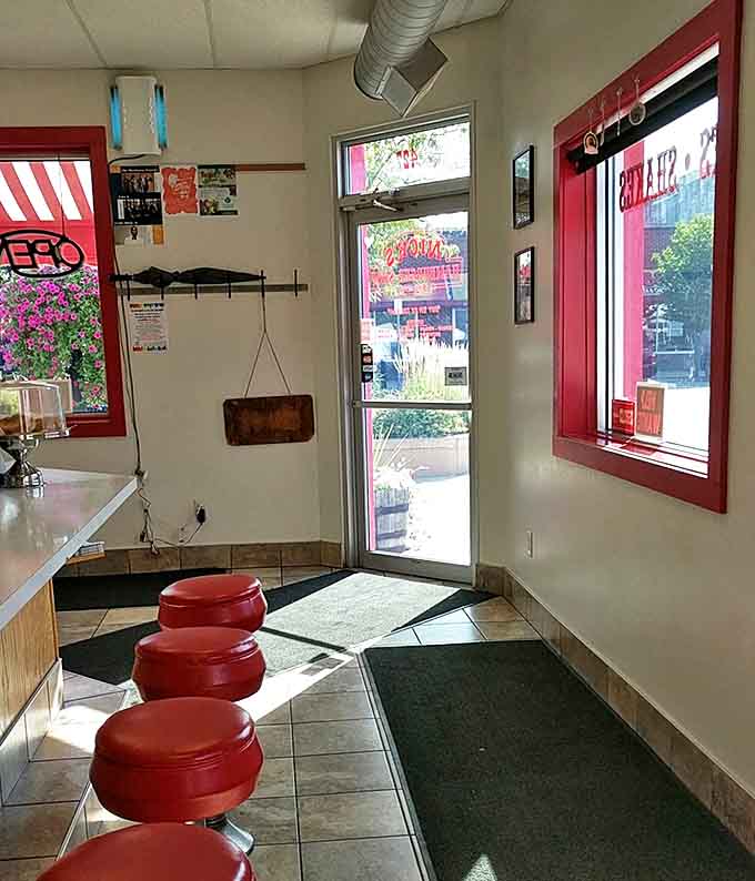 Sunlight streams through red-trimmed windows, illuminating those famous counter stools where generations have experienced burger bliss.