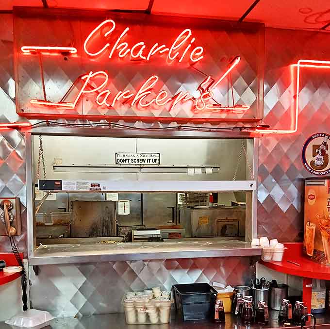 The neon glow of Charlie Parker's sign illuminates the pass-through window where culinary magic happens, complete with the kitchen's perfect motto: "Don't Screw It Up!"