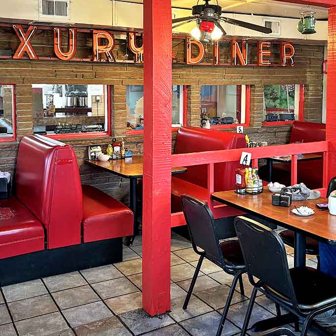 Neon signs cast a warm glow over brick walls and red booths, creating an atmosphere that Instagram filters have been trying to replicate for years.