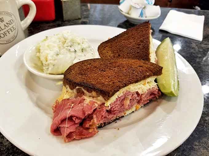 A proper Reuben sandwich with a side of potato salad – lunch perfection that proves Iron Town isn't just a breakfast one-hit wonder.