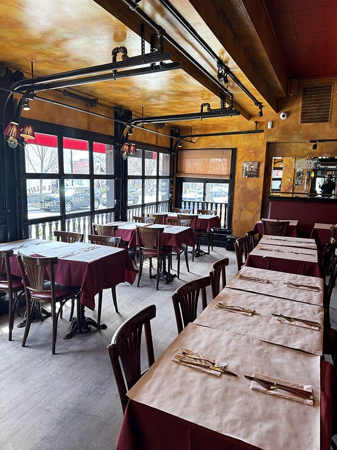 Tables await like blank canvases, each burgundy tablecloth promising stories that will unfold over excellent food and better conversation.