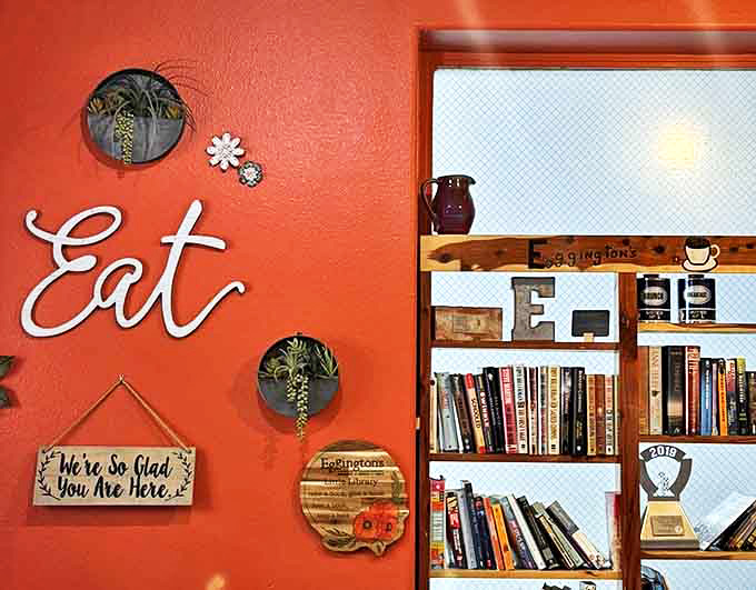 Books on shelves and plants on walls create a homey vibe, while the "We're So Glad You Are Here" sign feels like a warm hug before your first coffee.