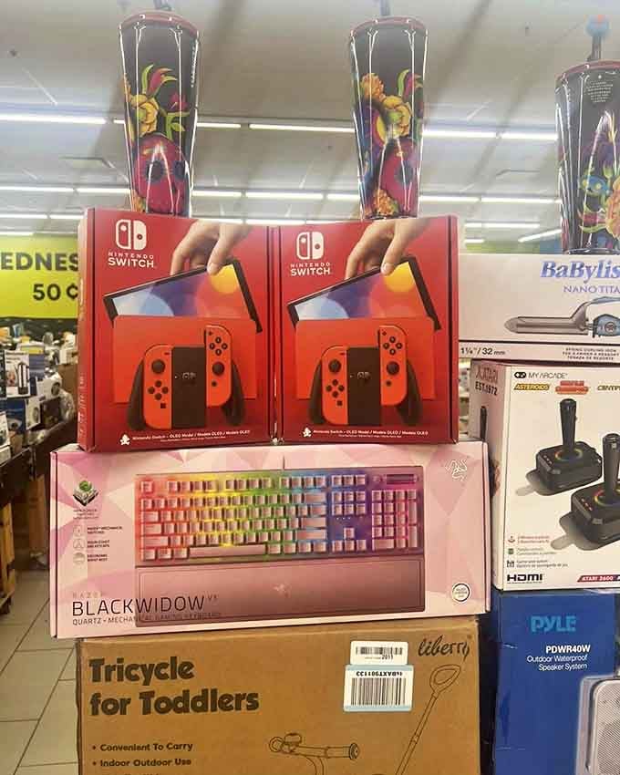 Nintendo Switch consoles stacked casually like they're not the gaming equivalent of finding gold doubloons. Below, a rainbow keyboard beckons to serious gamers.