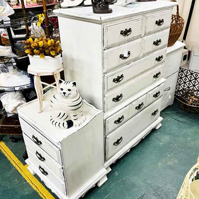 This shabby-chic dresser isn't just furniture – it's potential. Add the ceramic cat, and you've got yourself the beginning of a design story.